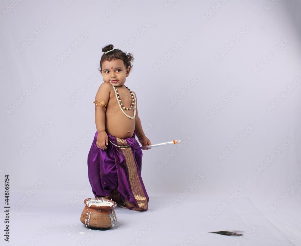 Janmashtami concept- adorable Indian baby in krishna kanha or kanhaiya dress posing with his ...