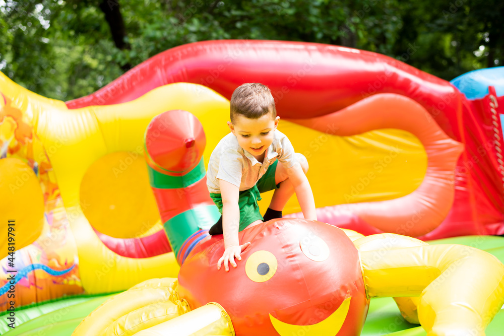 Little boy child having fun and jumping on an inflatable trampoline in ...