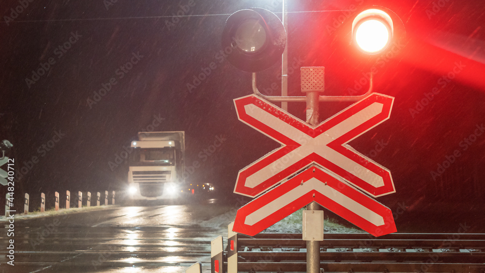 Train crossing gates closed at night. Train grade crossing with ...