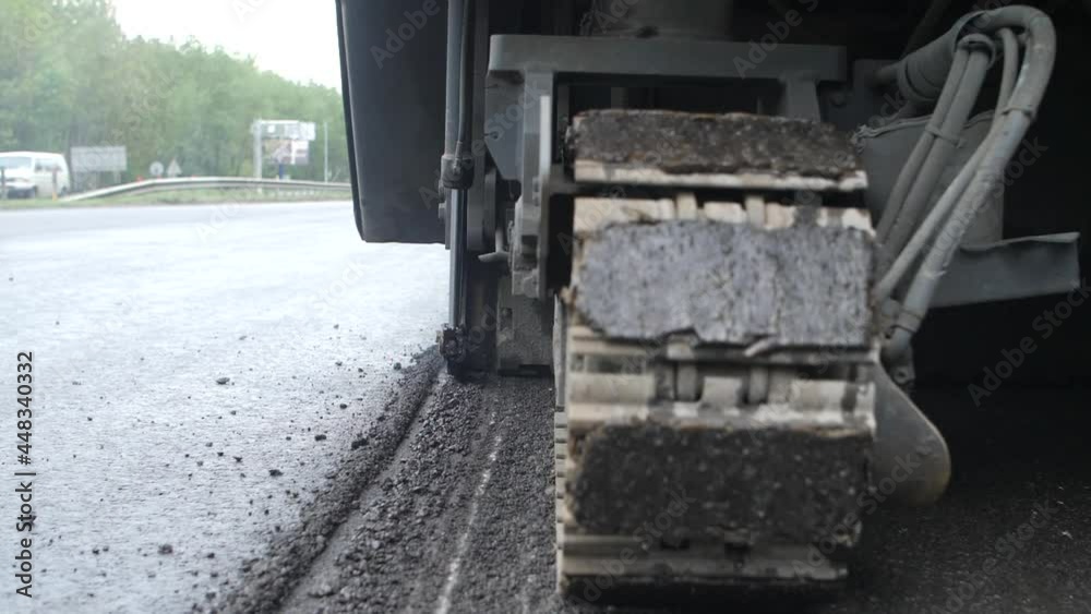 Close-up view of tracked heavy-duty cutter machine cutting asphalt ...