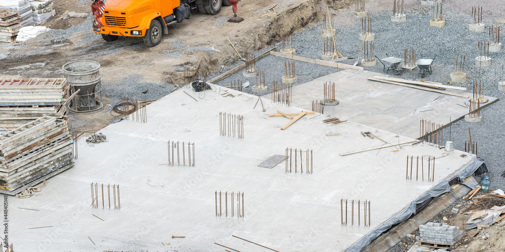 concreting work: construction site worker during concrete pouring into ...
