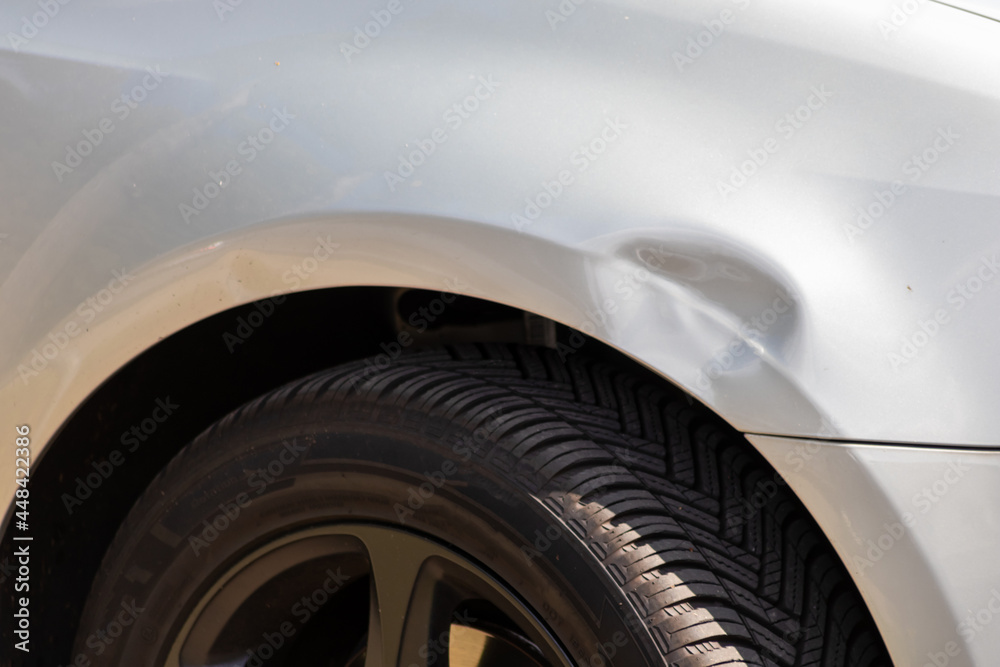 Dented car wing and fender with scratches and bumps after crash and car ...