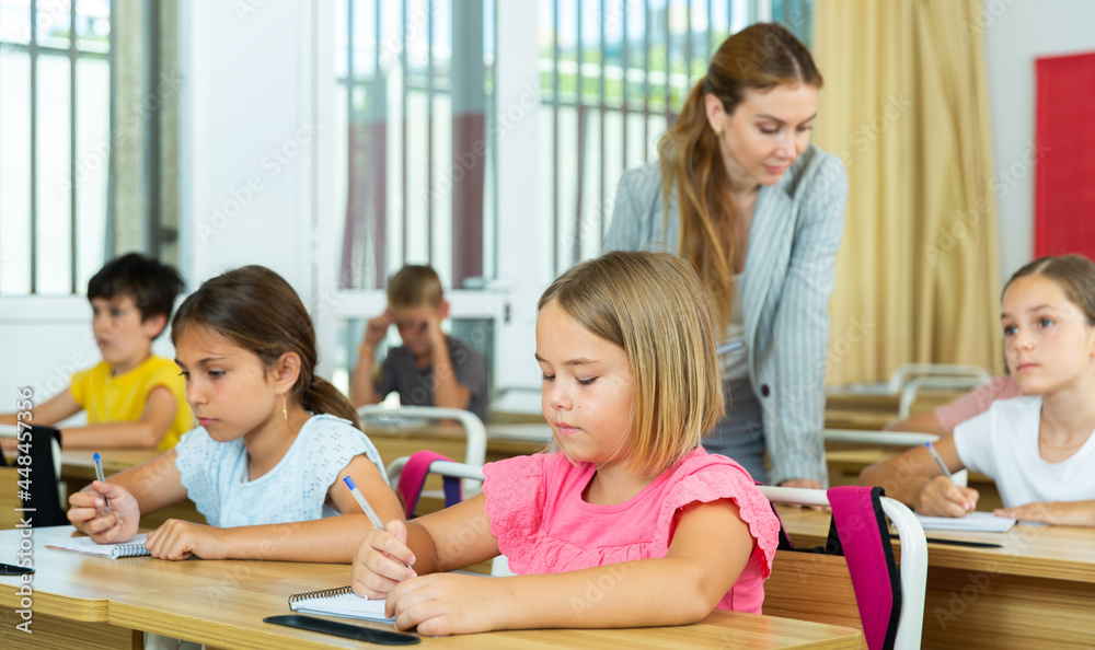 Diligent elementary school student preteen girl studying with ...