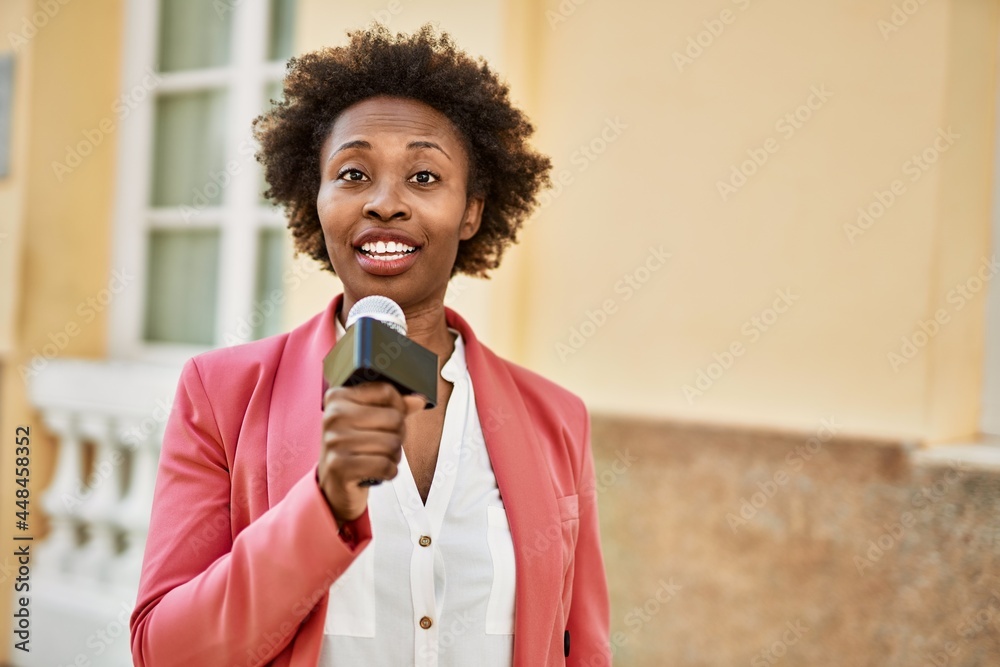 Young african american woman journalist holding reporter microphone ...