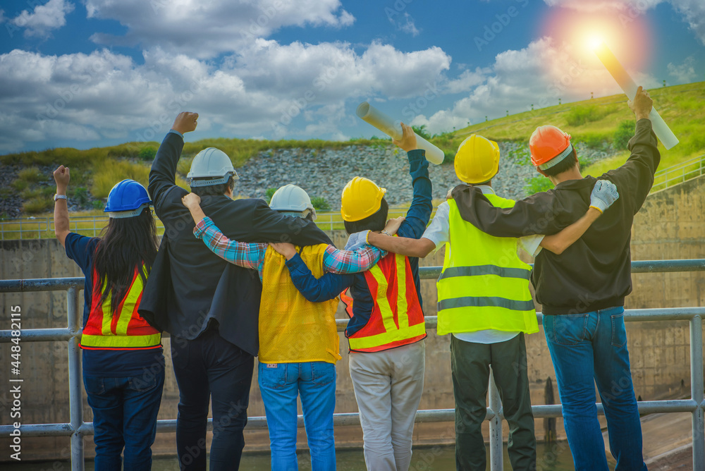 Group of engineer show hand up to cheer up with group at construction ...