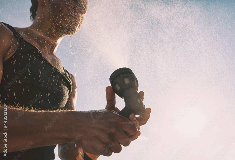 Foto de Man is refreshing himself with water spray gun in the hot ...
