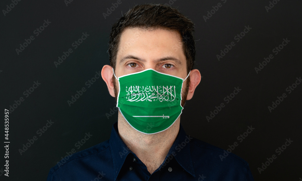 Man wearing Saudi Arabian flag protective medical face mask. He looks ...