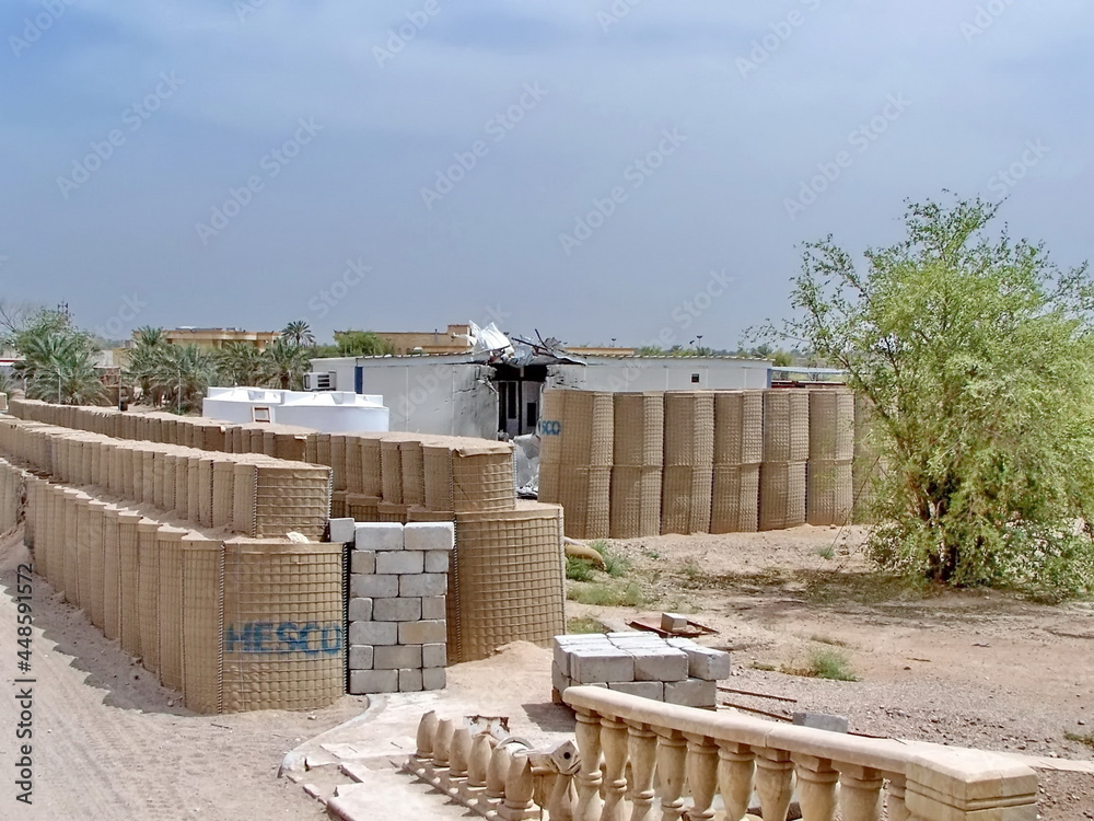 Foto de Sand filled blast barriers around a bombed out trailer at a ...
