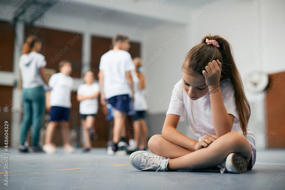 Sad schoolgirl feeling left out during physical activity class at ...
