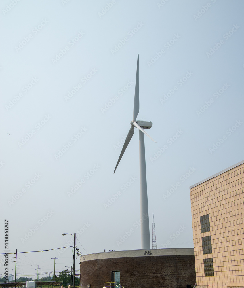 Wind turbine near a large brick tank that says water bio solids Stock ...