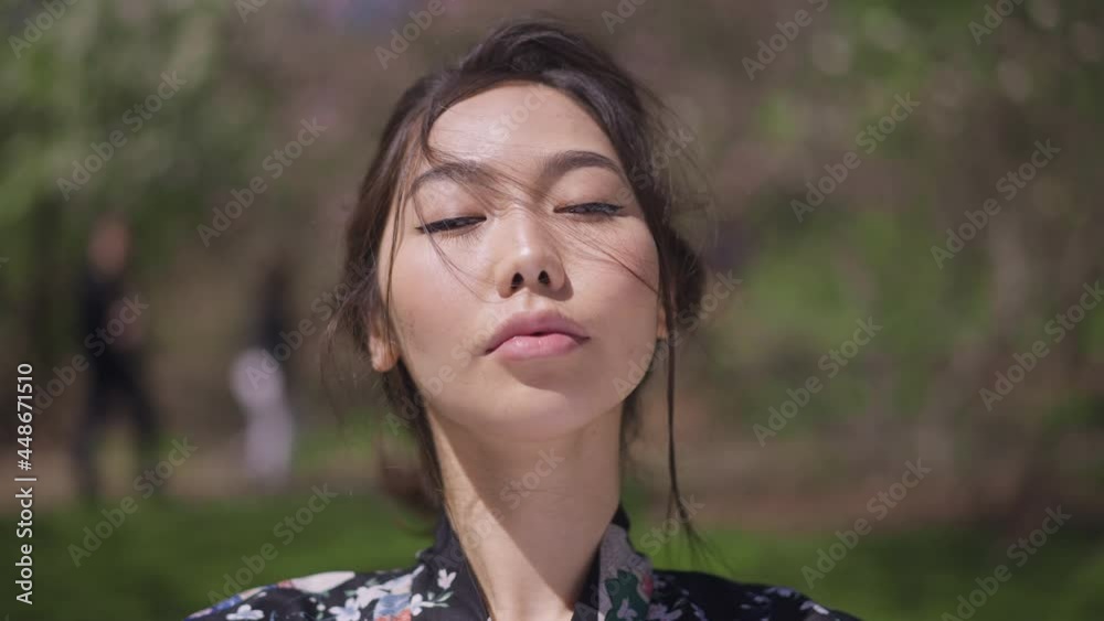 Front view headshot of confident beautiful Asian young woman unbinding ...