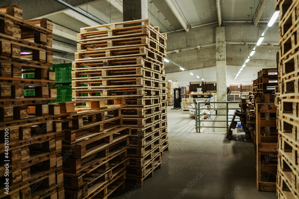 Bunch of wooden pallets in the warehouse. Empty warehouse space with ...