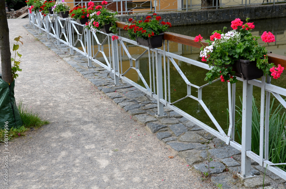 seafront with metal railings and plastic boxes attached to the handrail ...