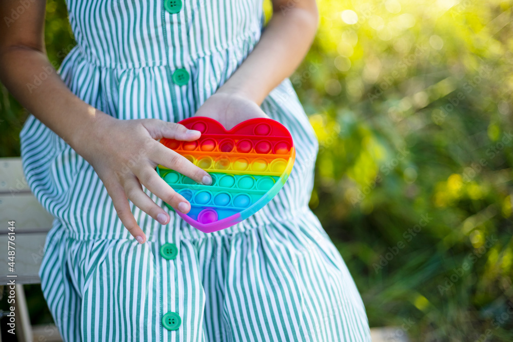 Blonde girl plays with colorful pop it. Funny trendy silicone ...