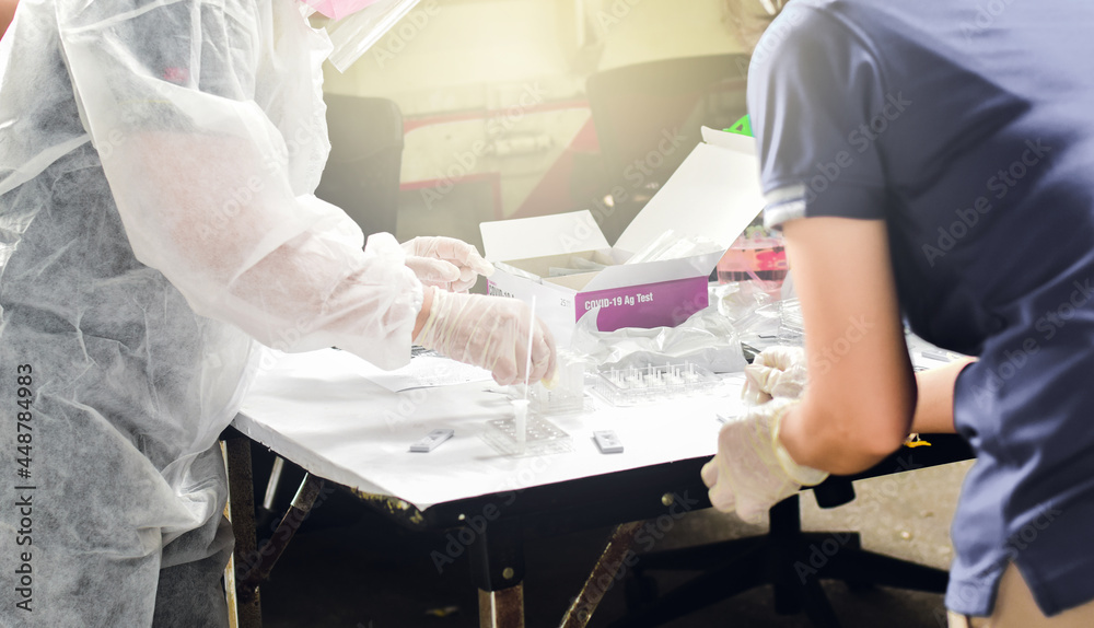 Doctor and female assistant testing for COVID-19 on a table with ...
