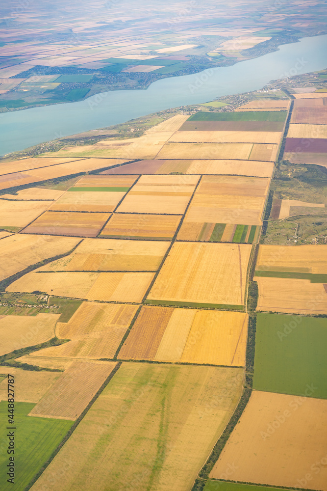 Land view through the airplane window. Fields, roads, rivers from a ...