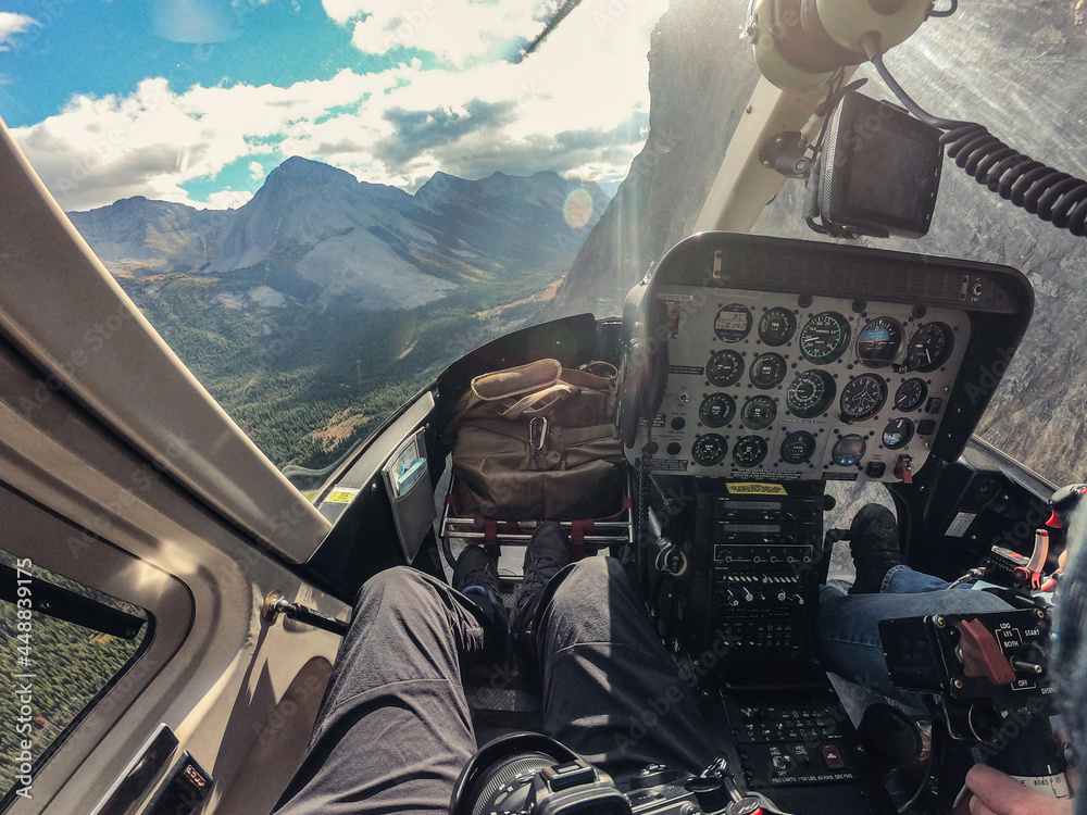 Inside of cockpit a helicopter flying over Rocky mountains in national ...