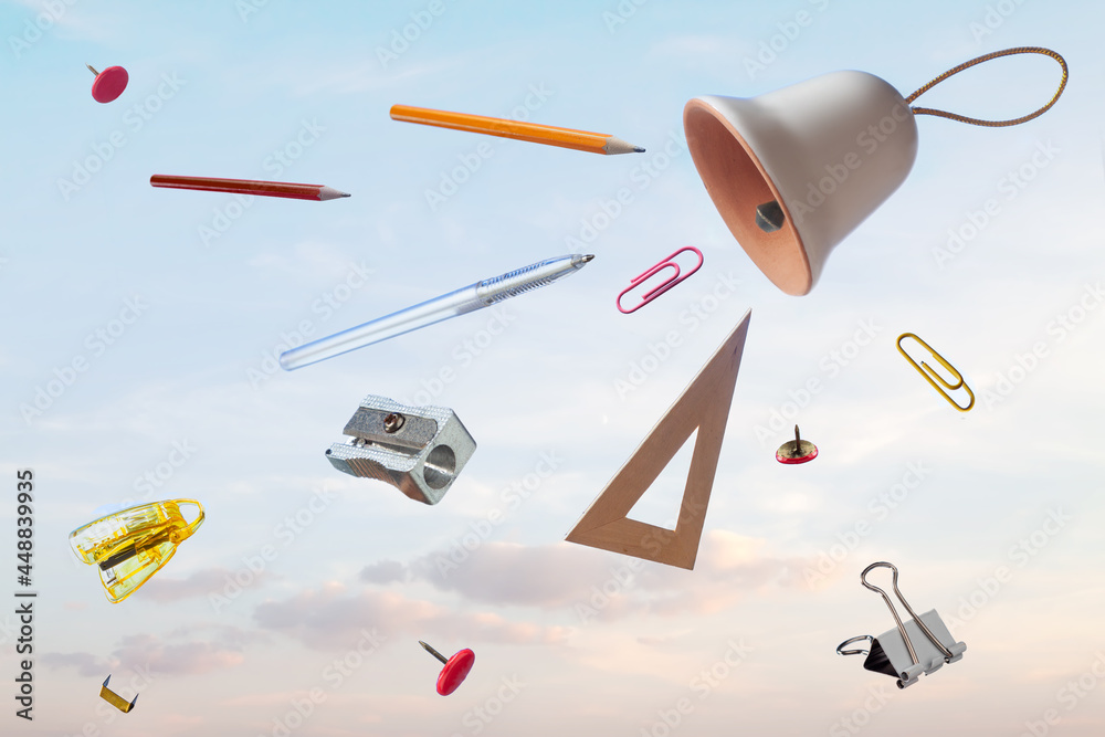 Flying school supplies after ring bell blue sky background. Back to ...