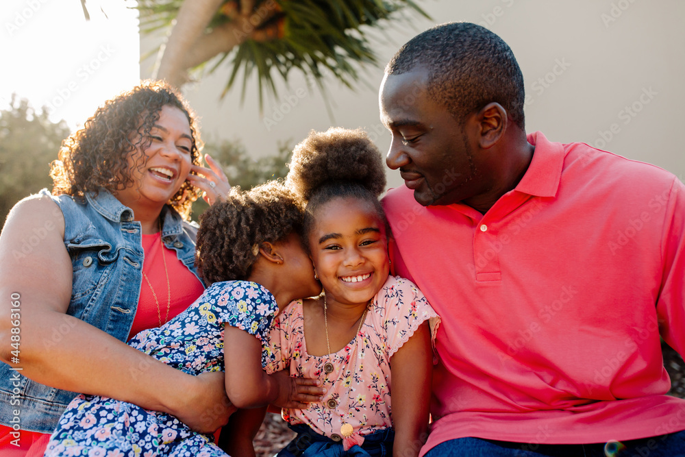 Parents hugging happy daughters outdoors Stock Photo | Adobe Stock
