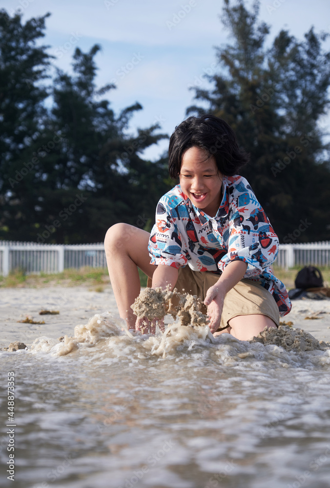 Cute beautiful Asian girl playing sand sculpture on the beach by the ...