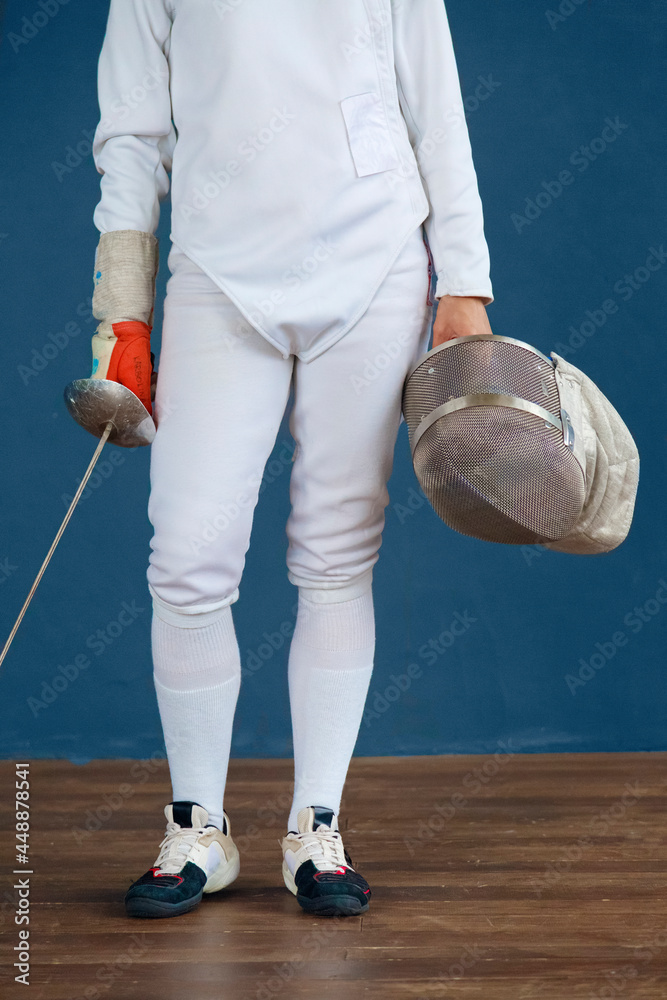 Crop fencer with mask and foil standing on wooden floor Stock Photo ...