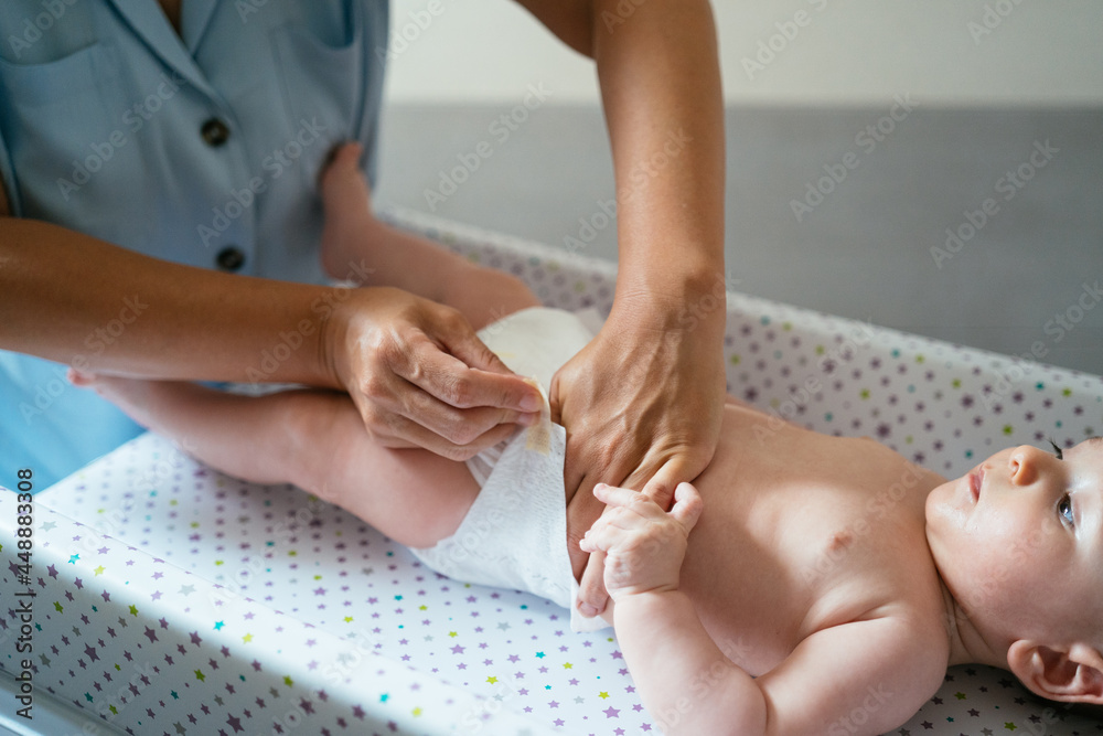 Mother Changing Baby Diaper Stock Photo | Adobe Stock