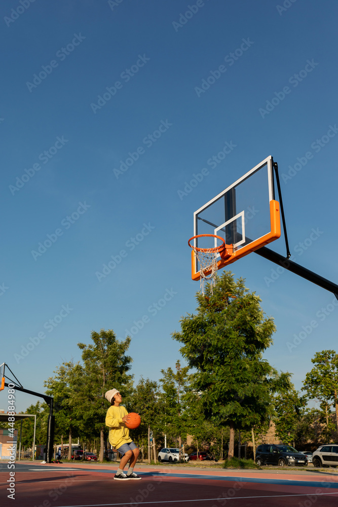 Boy playing basketball alone at basketball court Stock Photo | Adobe Stock