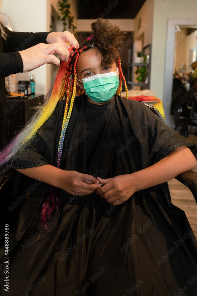 Camera aware masked girl getting box braids at salon Stock Photo ...