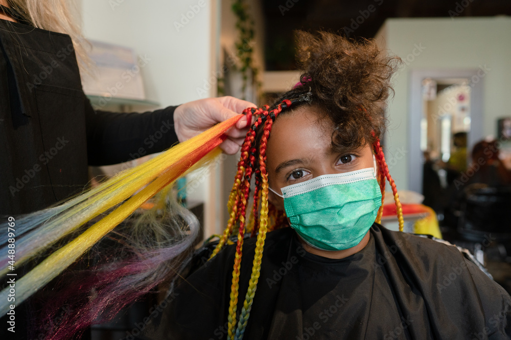 Camera aware masked girl getting box braids Stock Photo | Adobe Stock