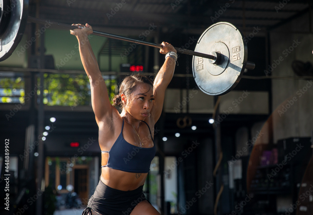 Muscular female athlete lifting heavy weights at gym Stock Photo ...