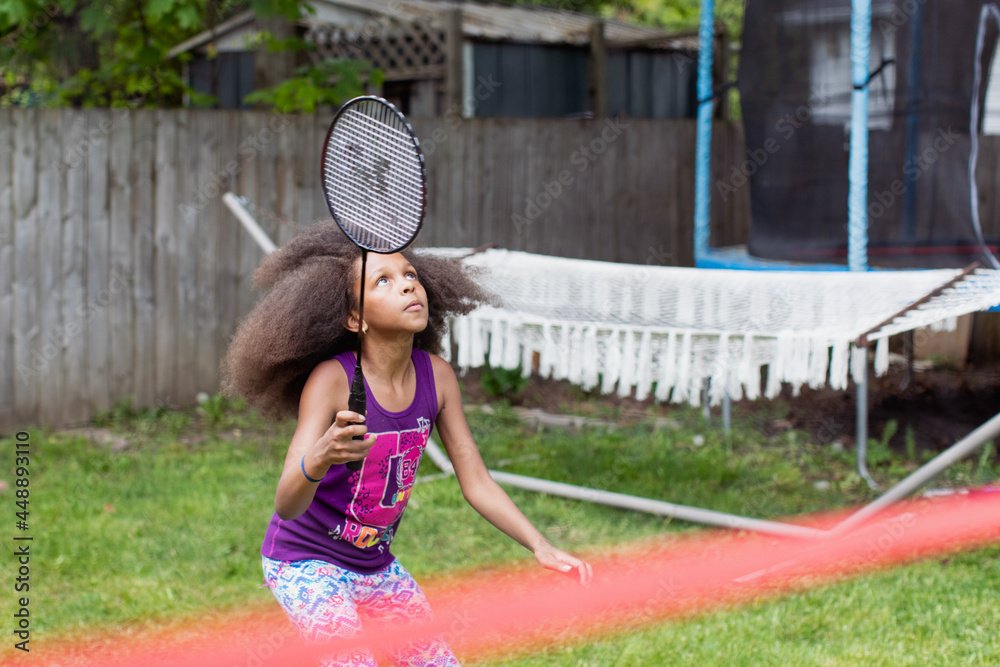 Young girl playing badminton with a racket Stock Photo | Adobe Stock