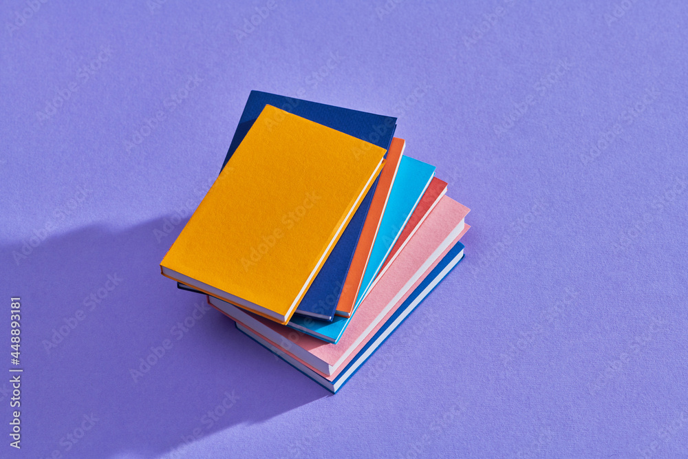 stack of books isolated on lilac Stock Photo | Adobe Stock