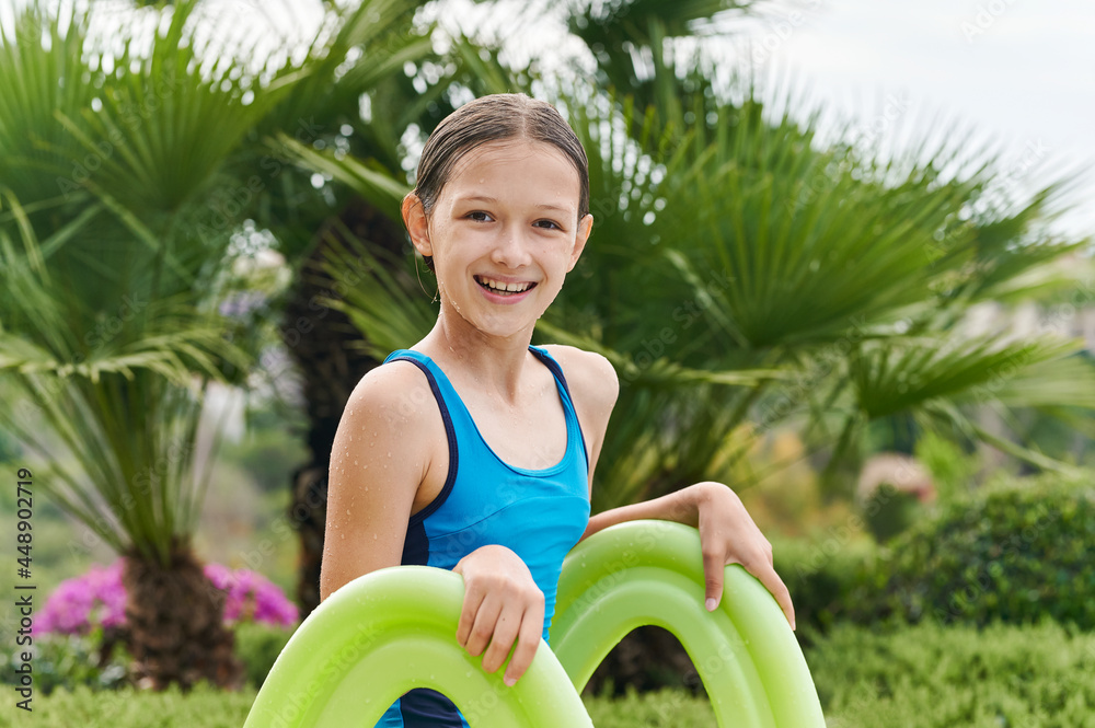 Smiling little girl standing on a pool slide Stock Photo | Adobe Stock