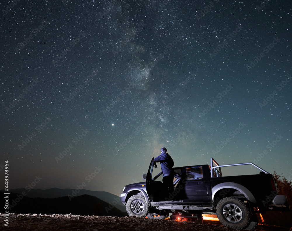 Rear view of young man who enjoying magic Milky Way and many stars in ...