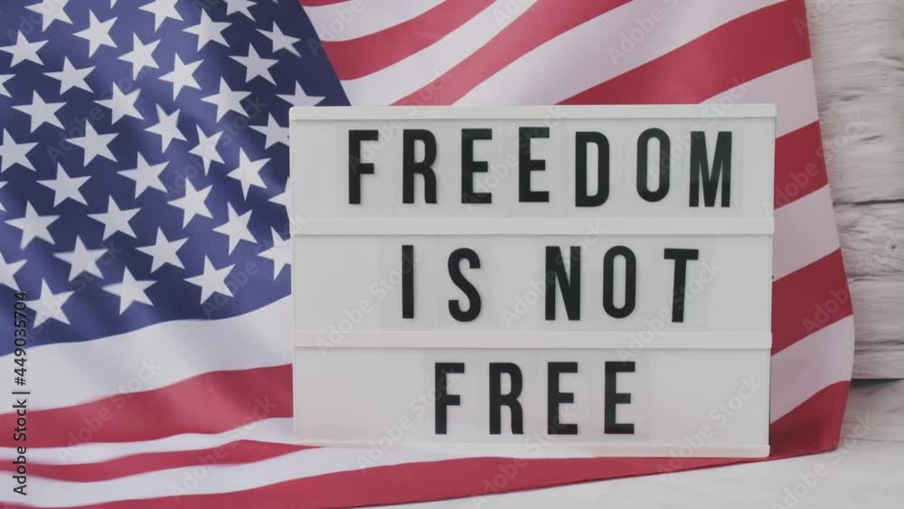 4k Waving American Flag Background. Lightbox with text FREEDOM IS NOT ...