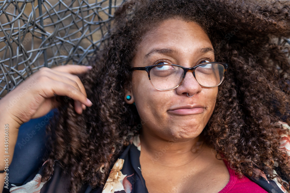 African American woman with long curly hair and glasses is happy and ...