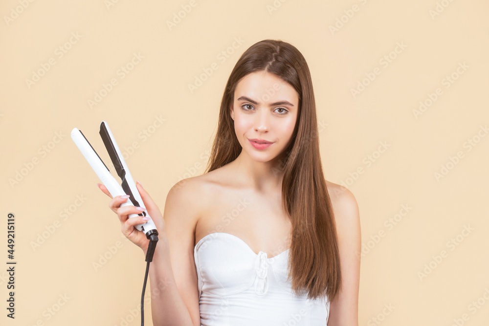 Beautiful smiling woman ironing long hair with flat iron. Woman ...