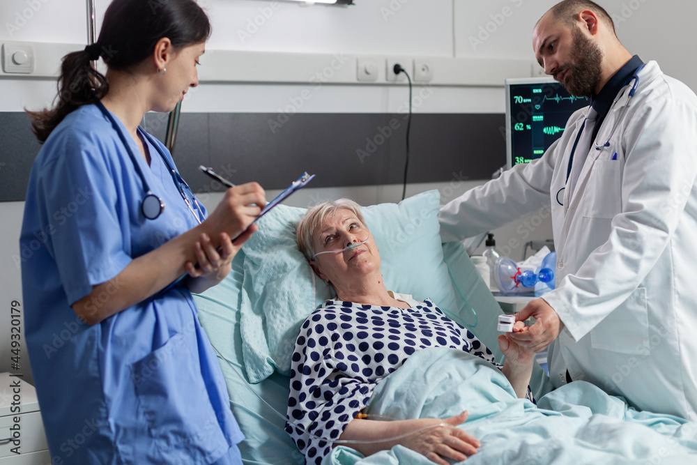 Doctor checking senior patient in hospital intensive care, checking ...
