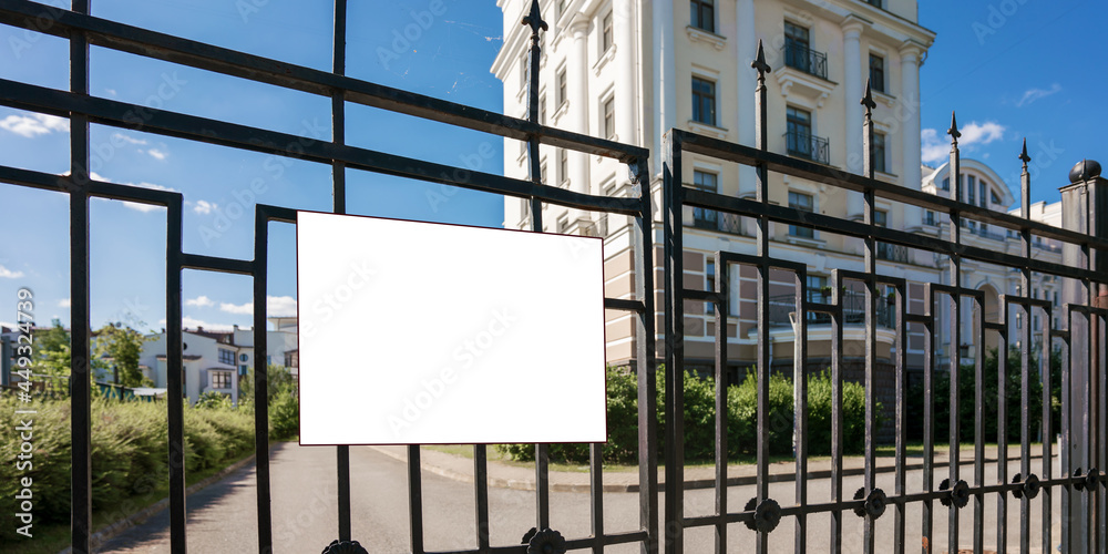 Blank white information sign board hangs on black metal fence Stock ...