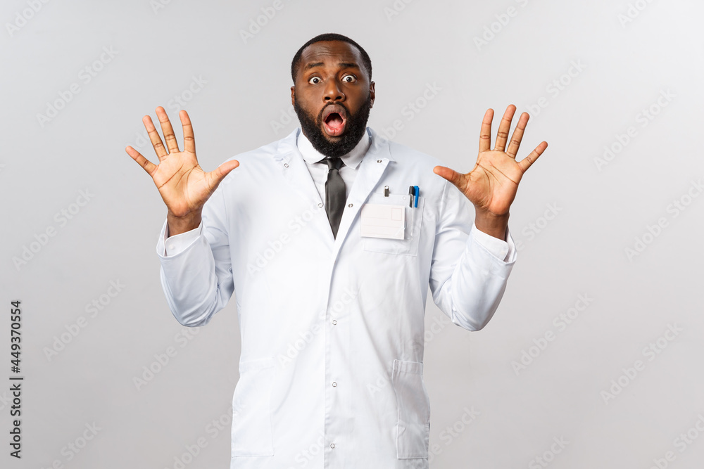 Portrait of shocked and nervous african-american male doctor raising ...