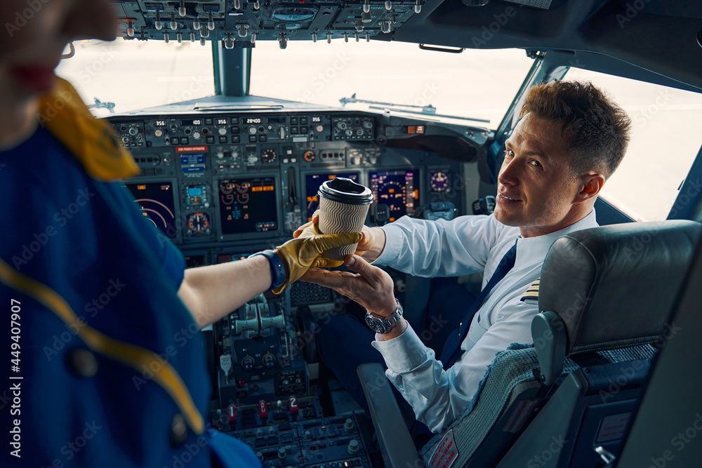 Stewardess serving coffee to a pleased co-pilot in the cockpit Stock ...