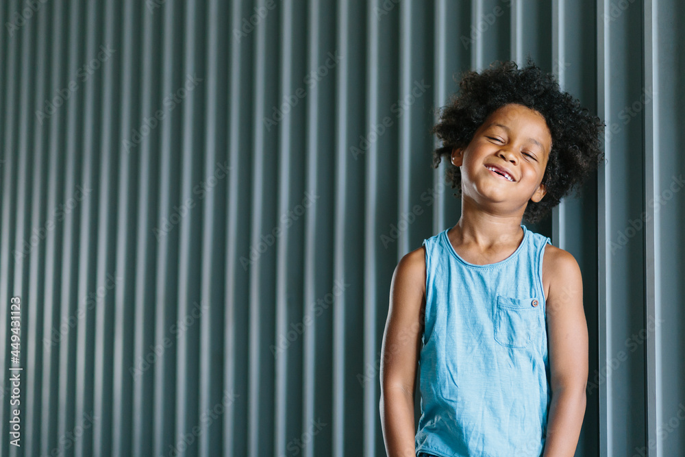 Black boy, with afro hair, looking at the camera. Smiling, missing his ...
