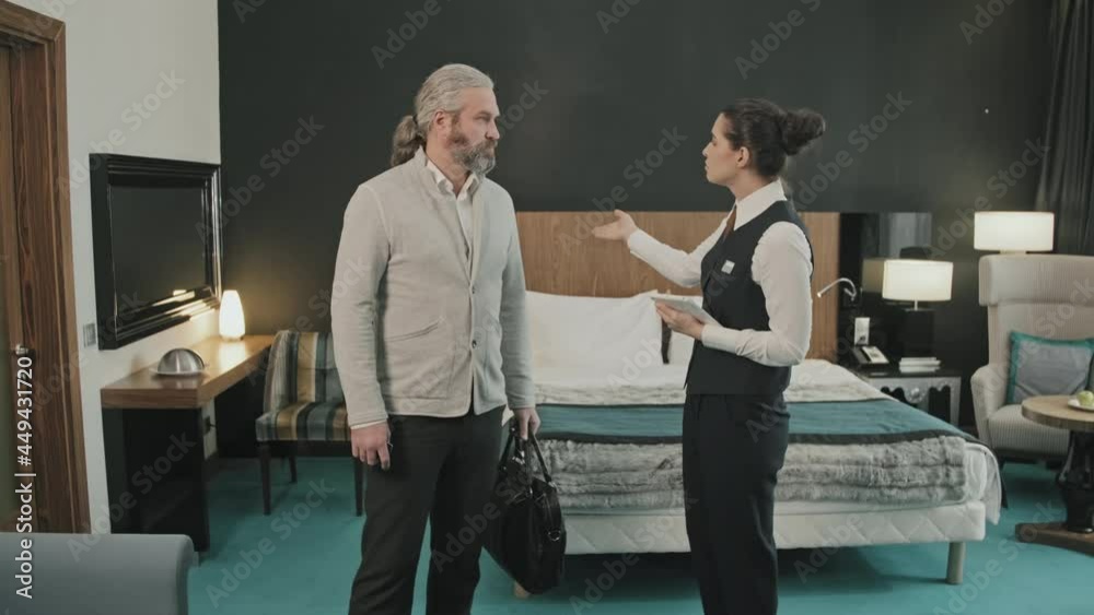 Medium shot of female hotel manager with digital tablet showing mature ...