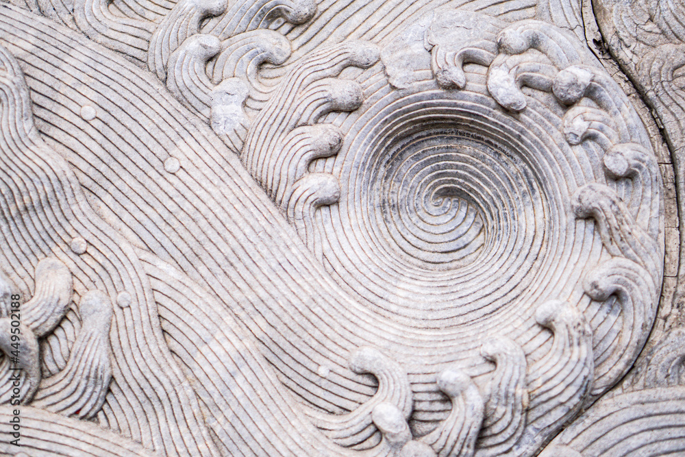 The stone is carved into a wave of water,Close-up of spiral pattern ...