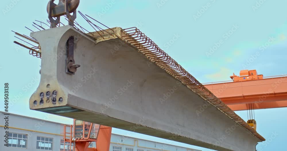 Close-up, a long concrete construction beam is lifted on a lift ...