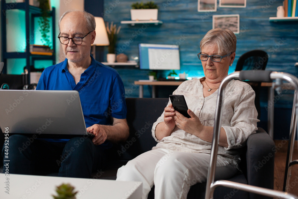 Retired elderly couple with smartphone and laptop computer using online ...