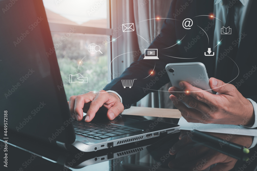 The man uses a laptop computer and mobile phone to send Digital ...