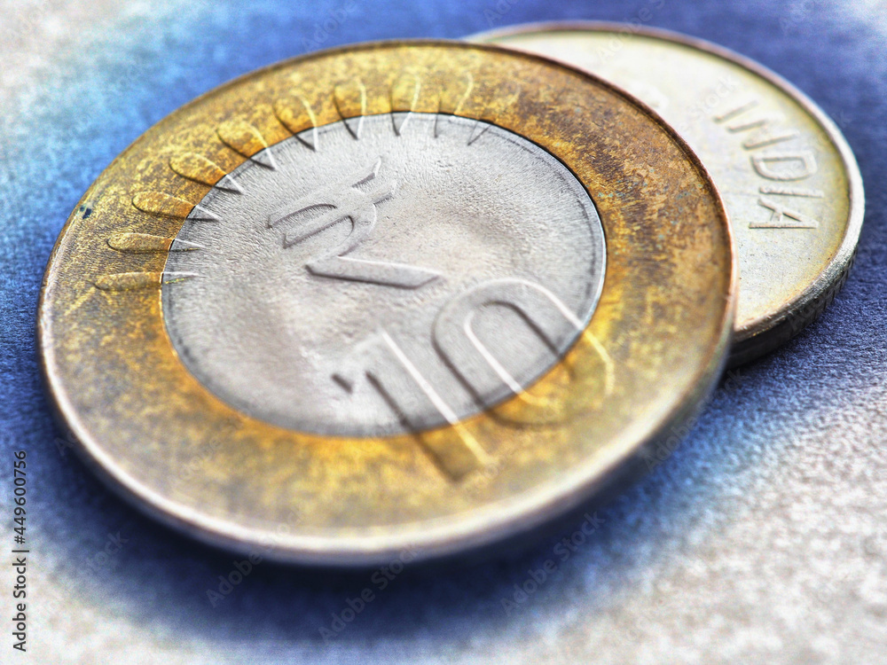 Two Indian coins lie on a textured surface. 10 rupee coin with the sign ...
