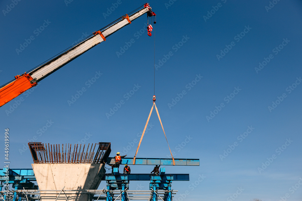 Industrial Crane lifting steel frame in mega construction site of fly ...