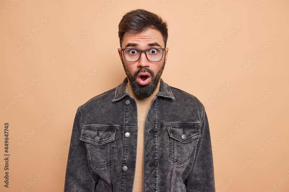 Portrait of scared bearded man stares in dibelief keeps mouth opened ...